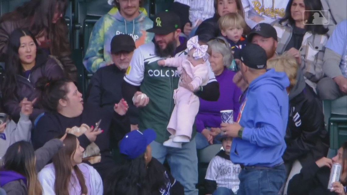 Dad catches foul ball while holding daughter at Rockies game | 9news.com