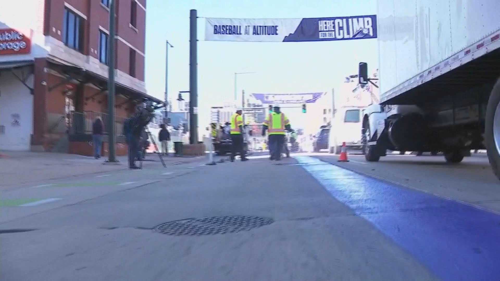 Crews paint purple stripe on Blake Street for Rockies' opener | 9news.com
