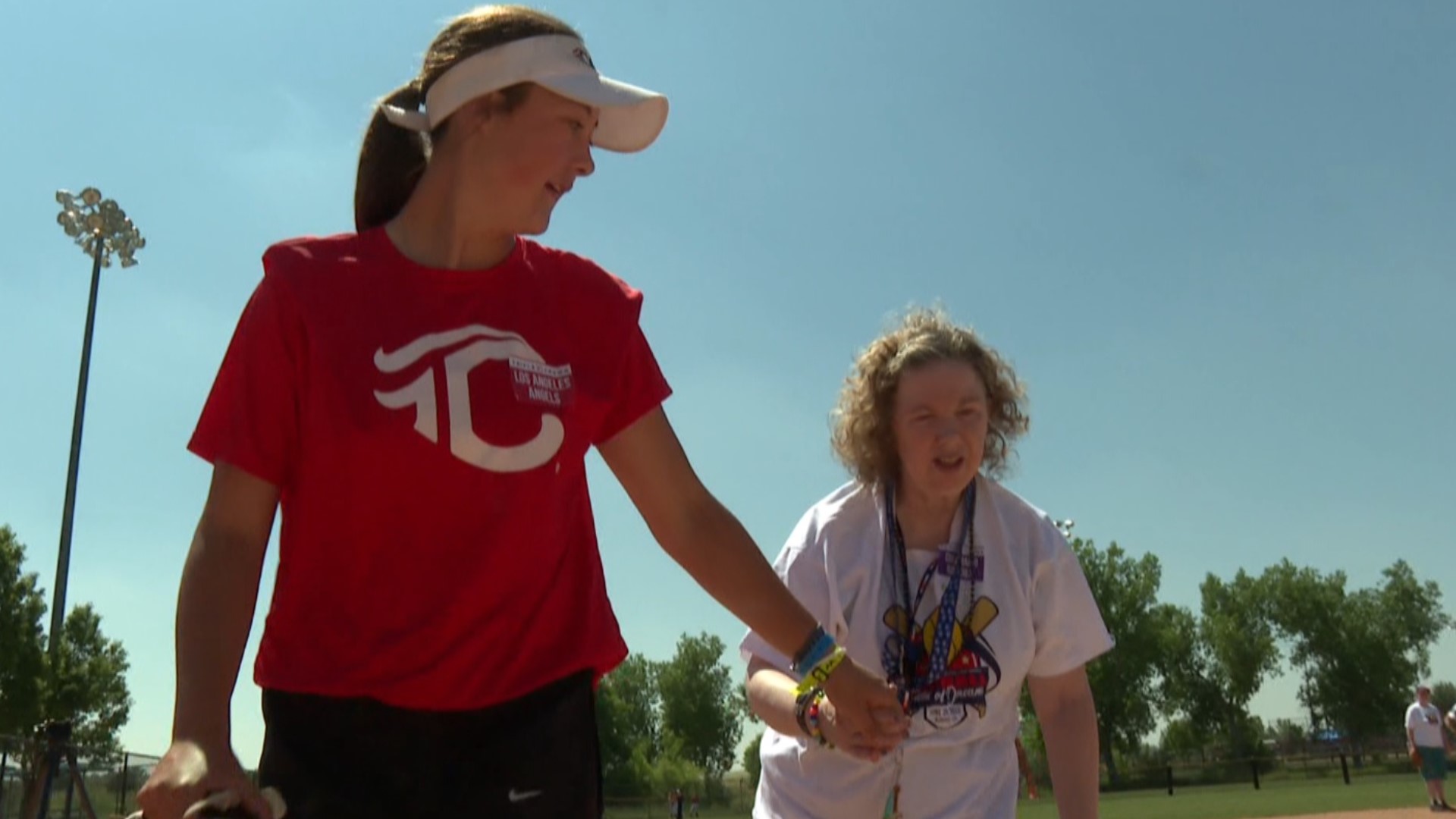 Softball players give back by volunteering with disabled athletes ...